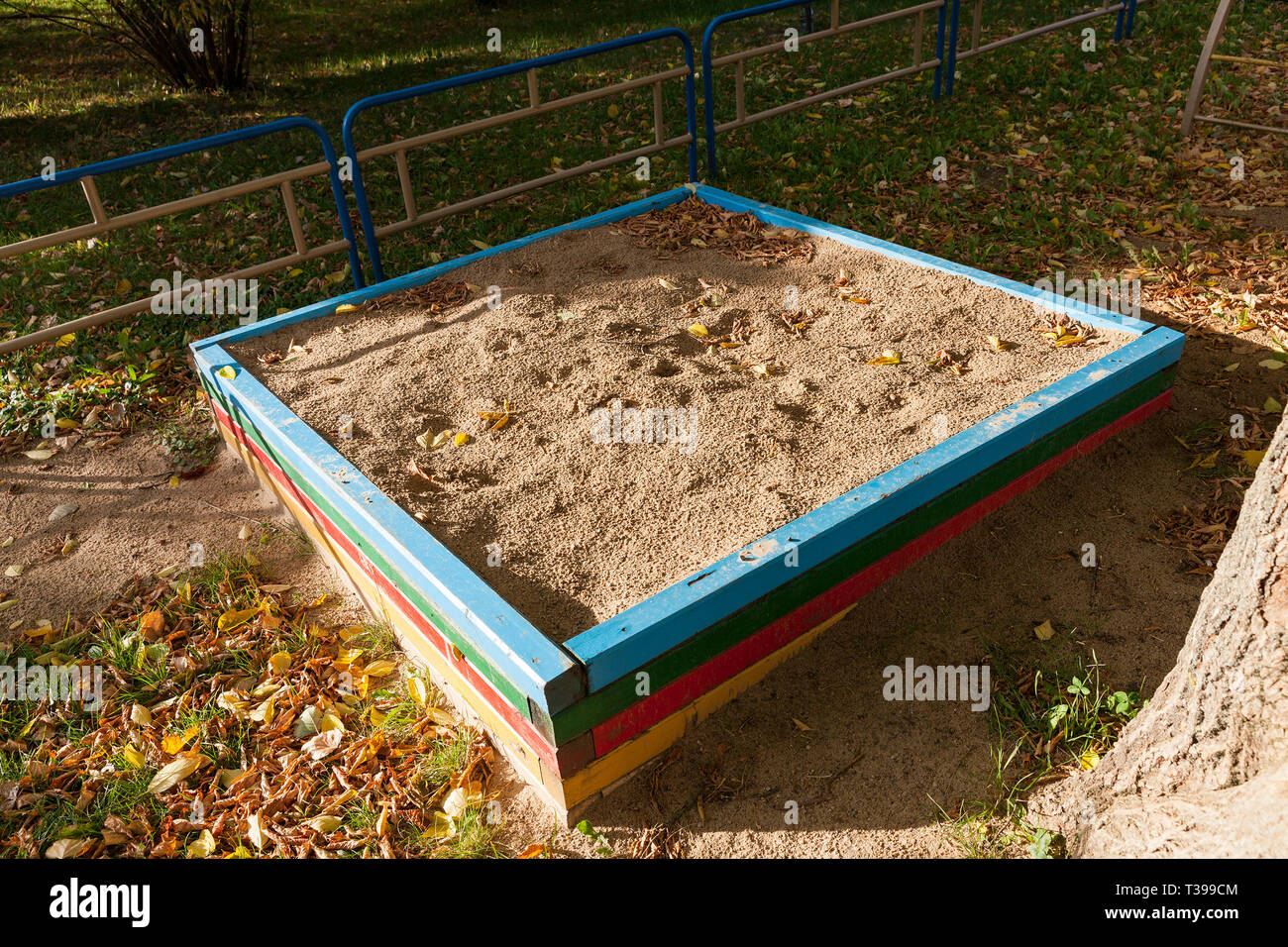 an old children's sandbox in the yard covered with yellow sand ...