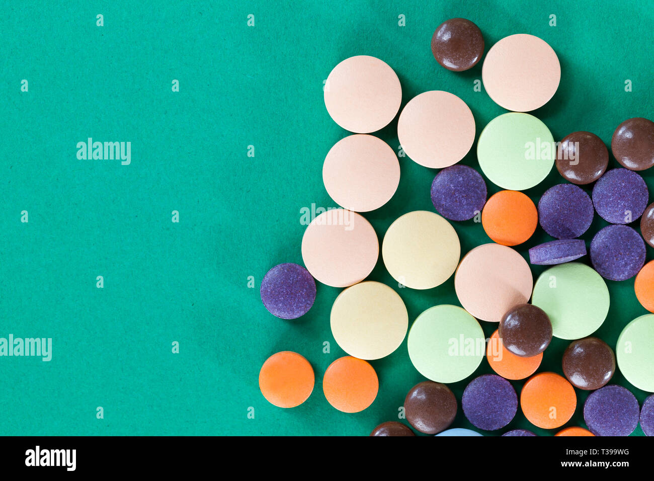 Multi-colored pills on a green background of various packs, a bunch of ...