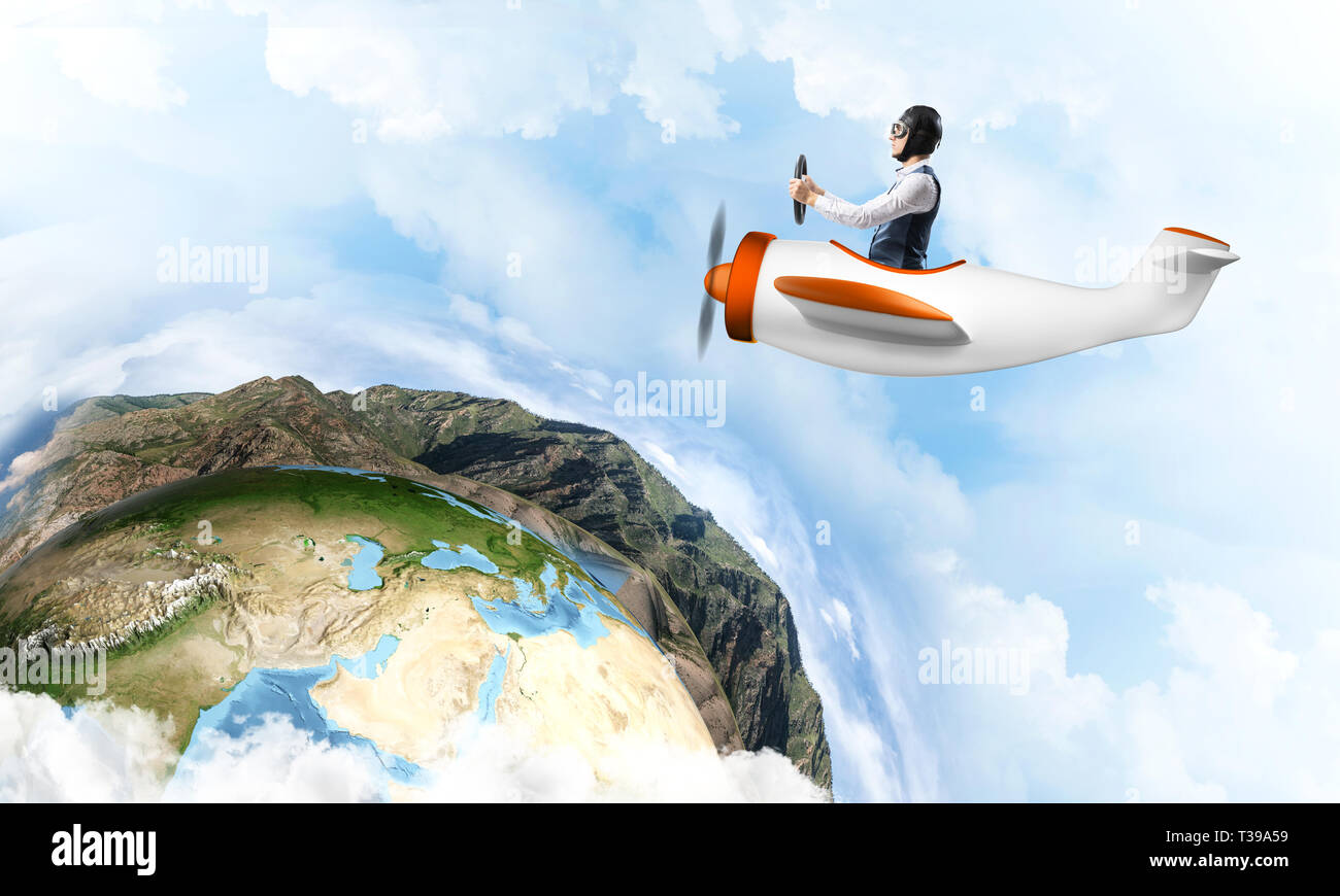 Happy pilot driving small propeller plane on background of blue sky ...