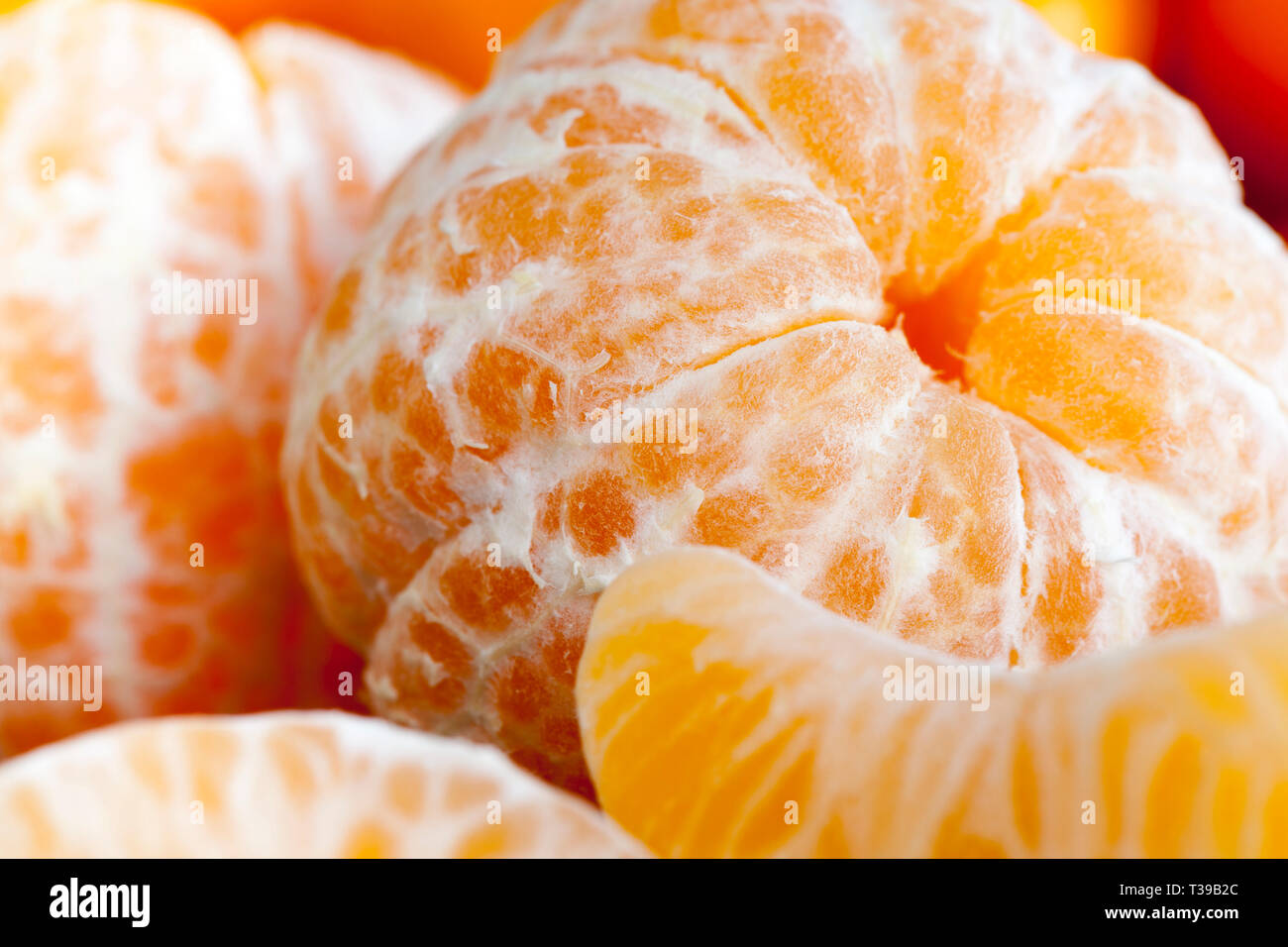 many whole and divided by slices part of ripe tangerine, real citrus ...