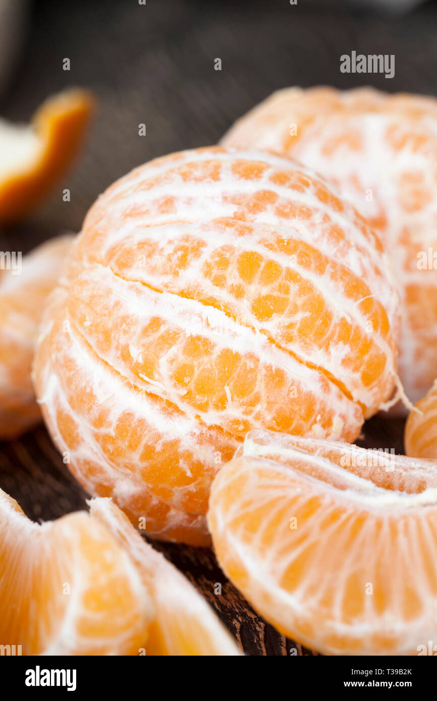 many whole and divided by slices part of ripe tangerine, real citrus ...