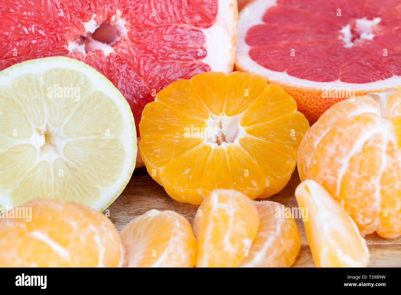 Peeled and cut half ripe citrus fruits, grapefruit, mandarin lemon ...