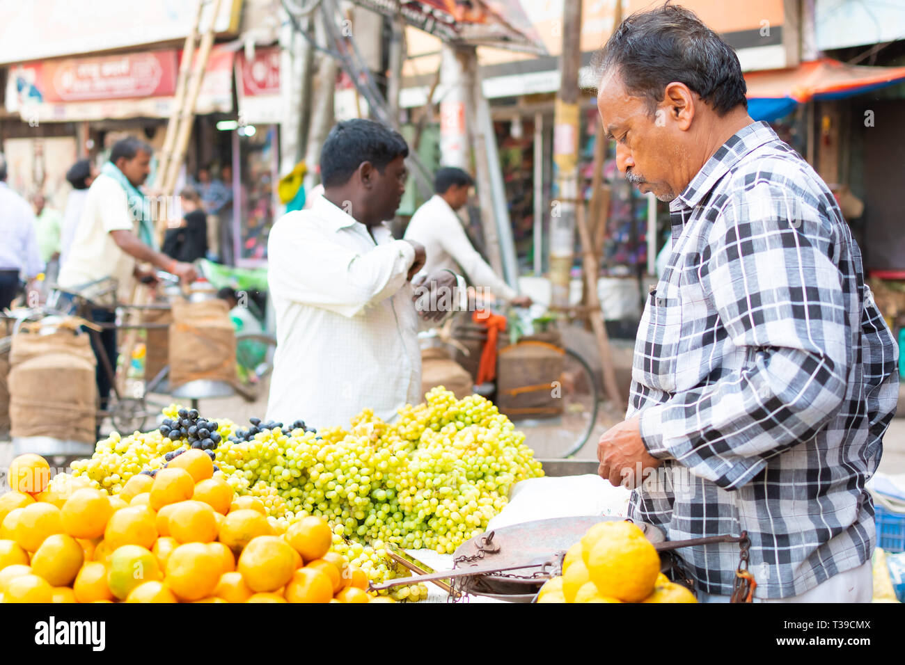 India, Varanasi, Mar 10 2019 - Unidentified vendor man sells and weighs ...