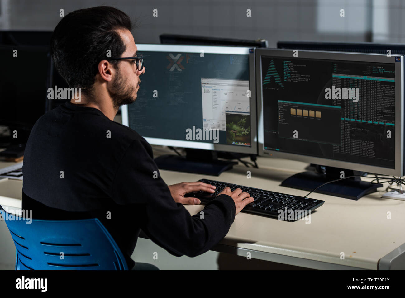 Young computer science student developing with his computer on a Linux ...