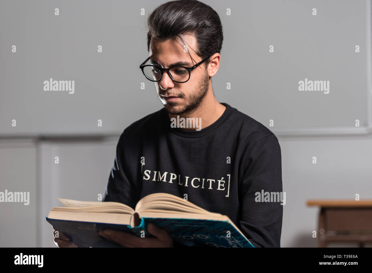 Young computer science student reads an advanced robotics book in ...