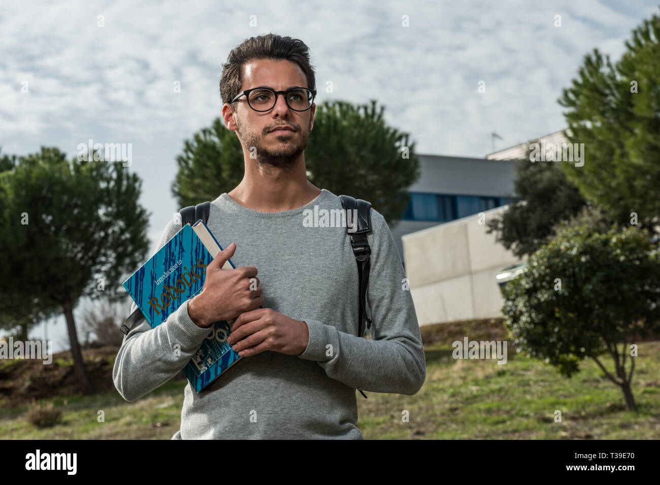 Young student of computer science poses with a robotics book next to ...