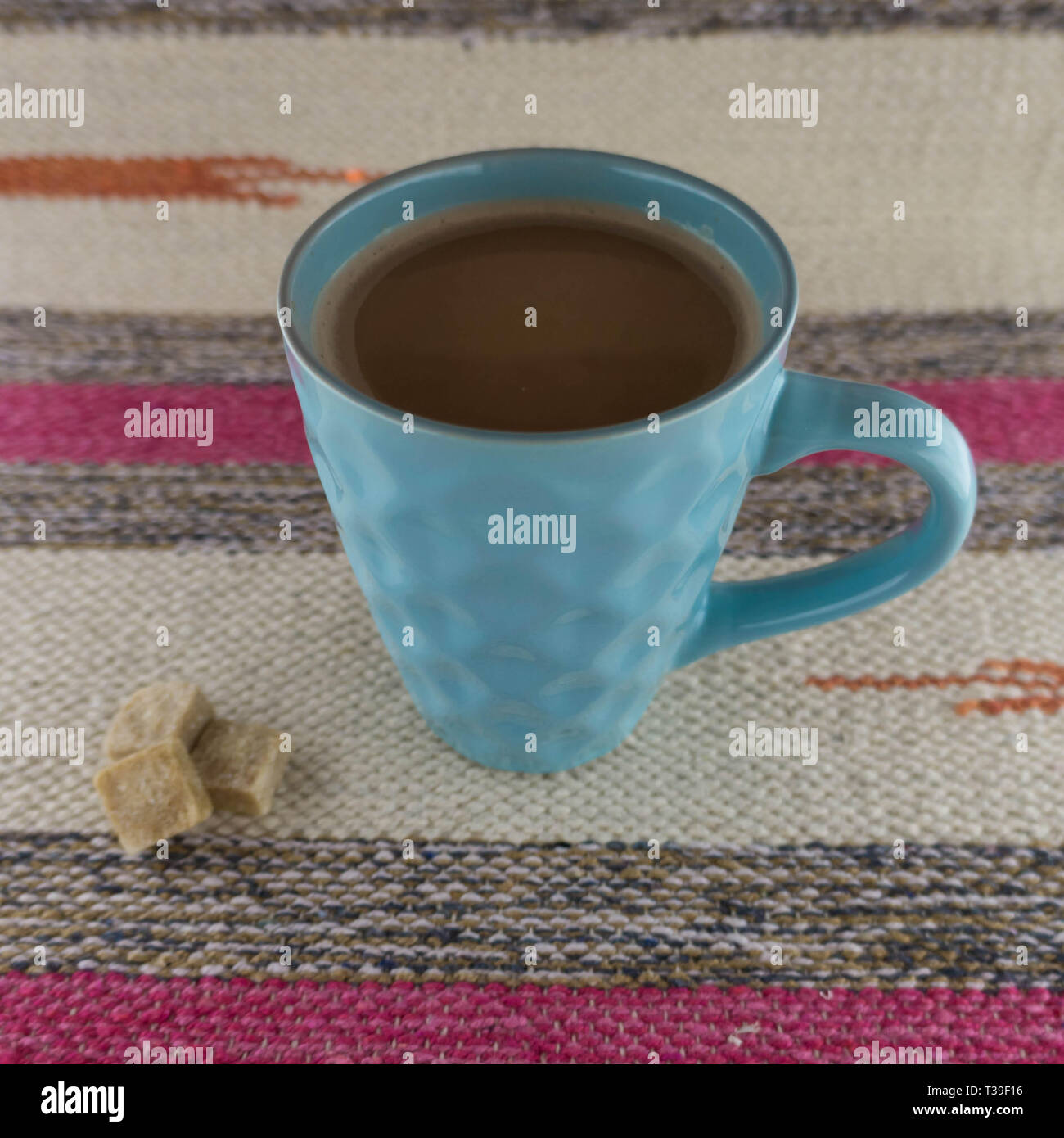 Turquoise Cup of coffee against the striped braided rug Stock Photo - Alamy