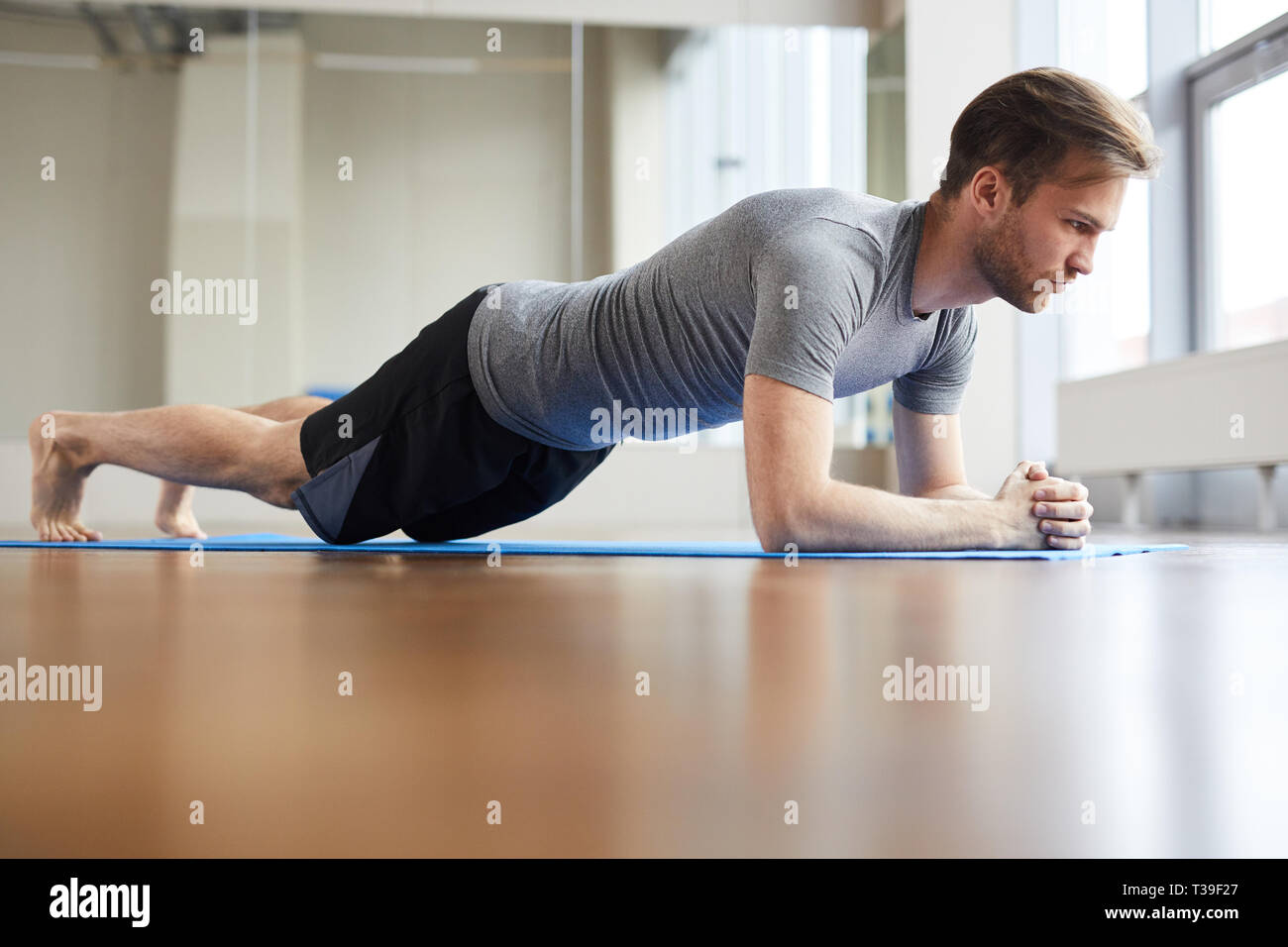Concentrated man doing plank pose Stock Photo - Alamy