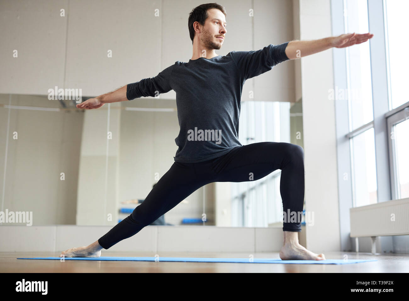 Slim man doing standing yoga pose Stock Photo - Alamy