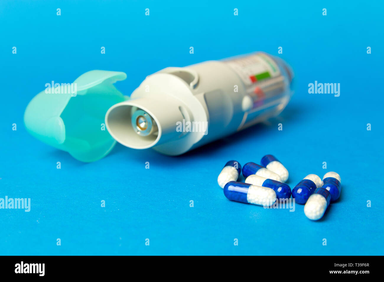 inhaler and pills against asthma on blue background Stock Photo - Alamy