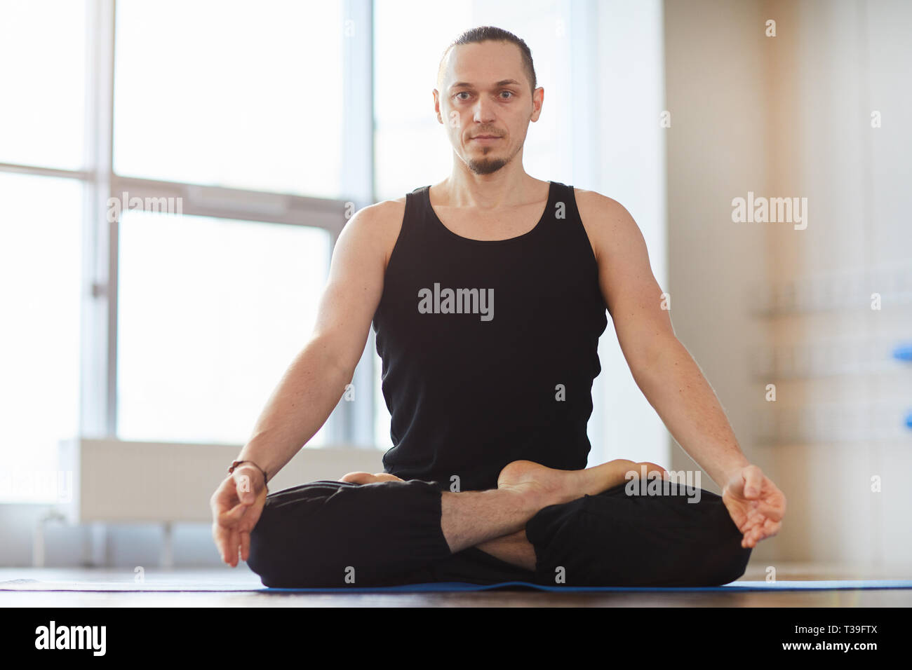 Muscled young man meditating alone Stock Photo - Alamy