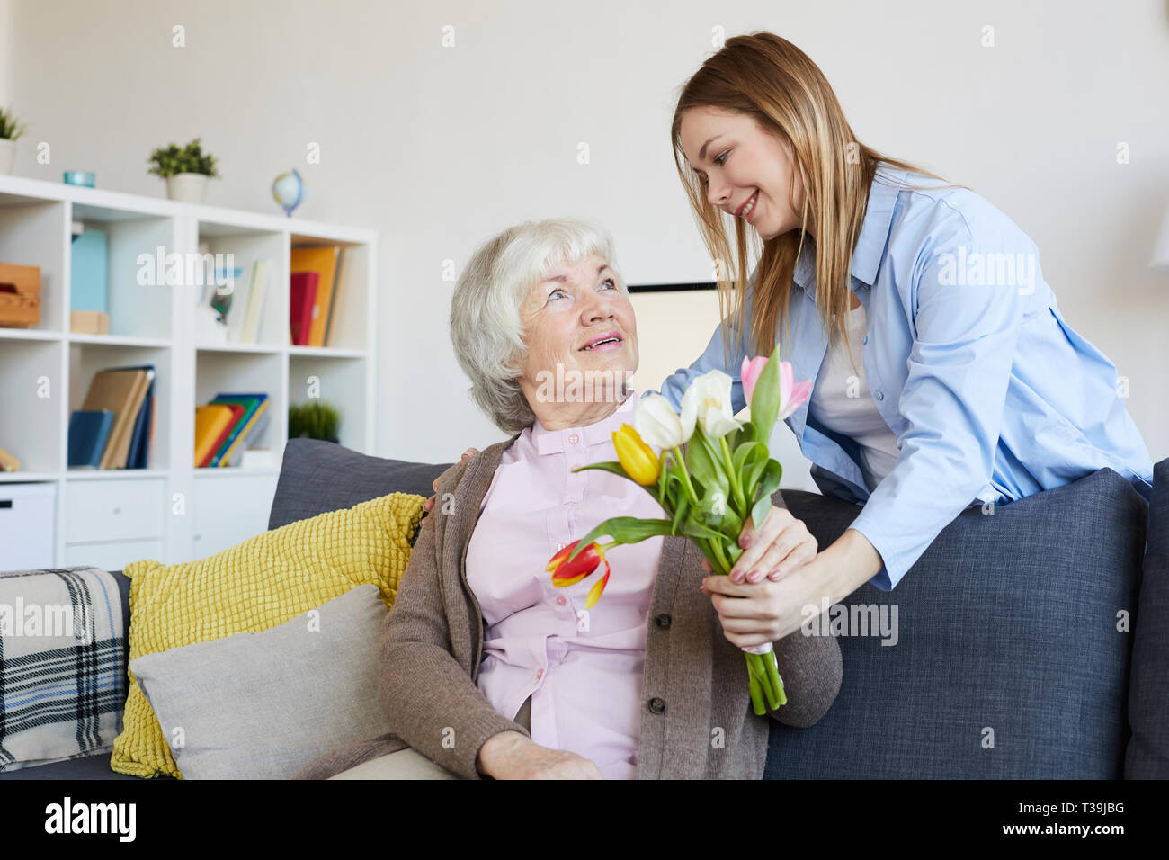 Woman Giving Flowers to Mother Stock Photo - Alamy