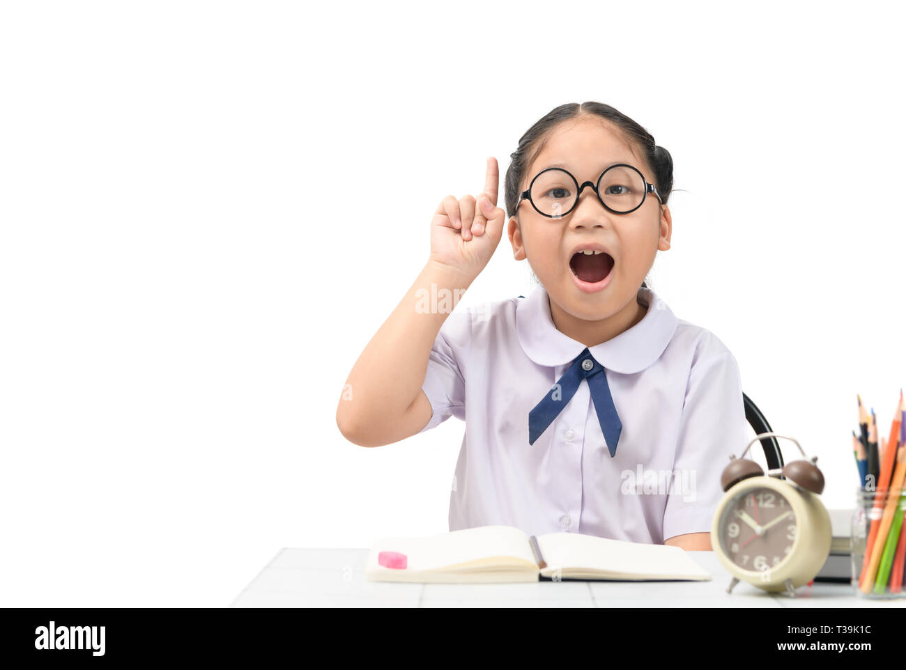 Cute student thinking while doing her homework on table isolated on ...