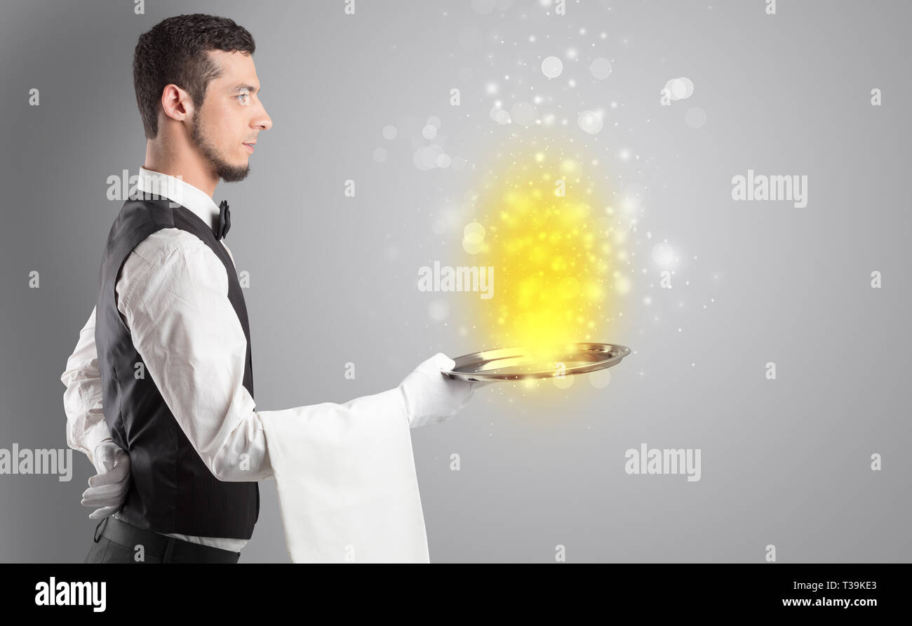 Elegant young waiter serving mysterious light on tray Stock Photo - Alamy