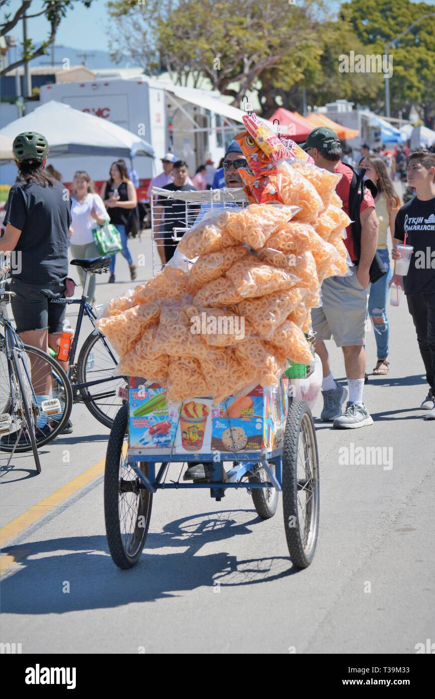 snack food vendor on a bike, tricycle, selling food at a street fair in ...