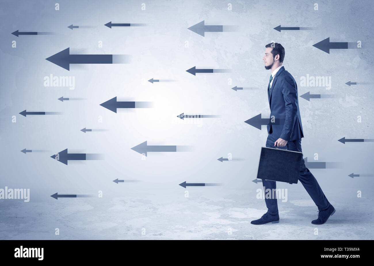Businessman walking with arrows on the background and briefcase on his ...