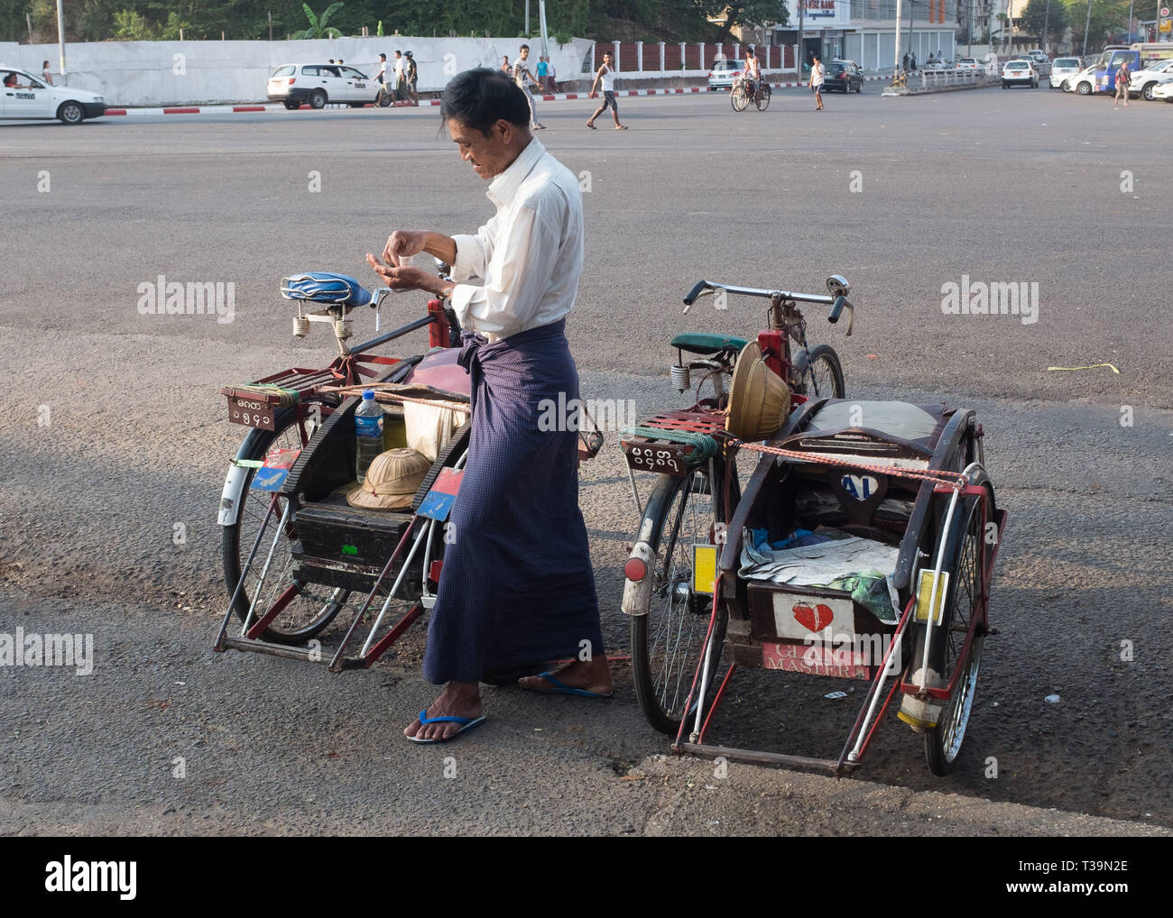 bicycle rickshaw rider waiting for customers in Yangon, Myanmar (Burma ...