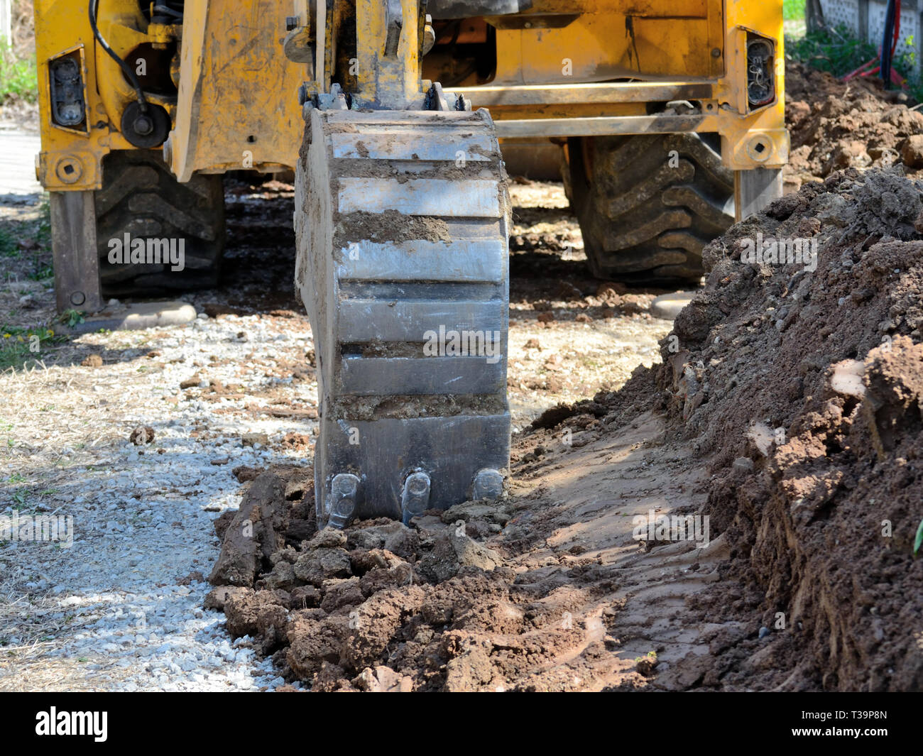 Excavator digging dirt ditch Stock Photo - Alamy