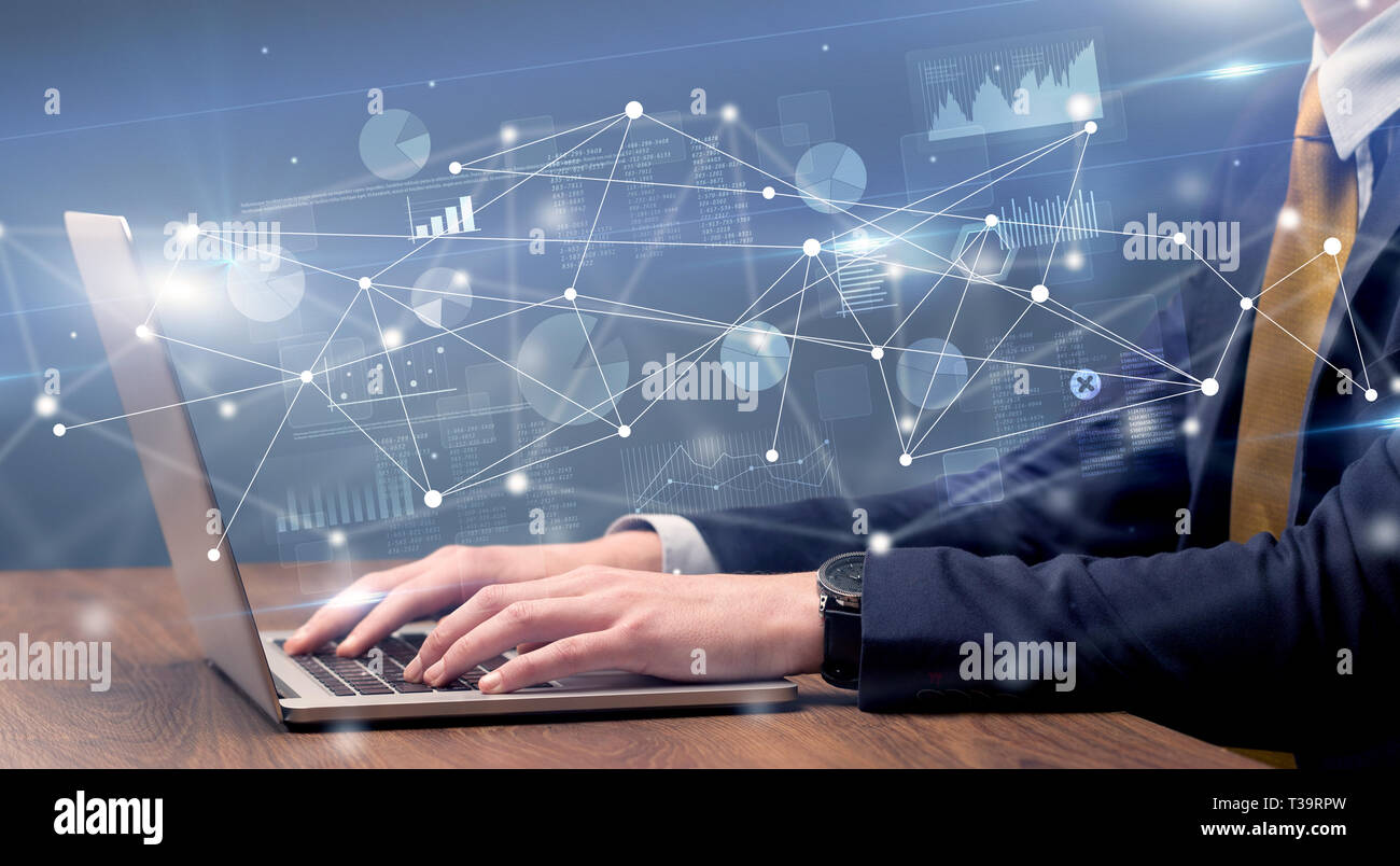 Businessman typing on laptop with linked reports charts grapghs around ...