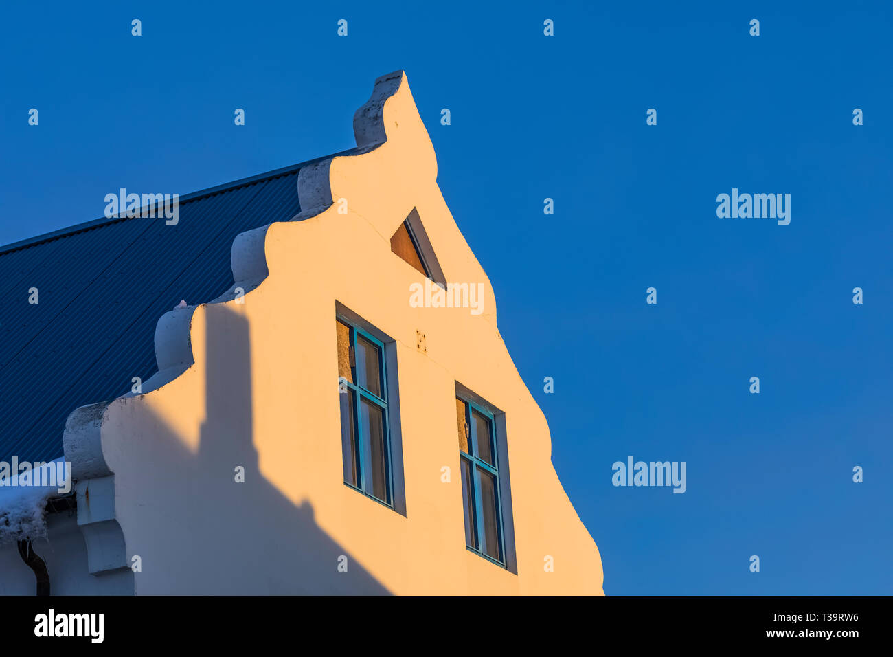 Scalloped facade of a poured concrete building in Hólmavík in winter in ...