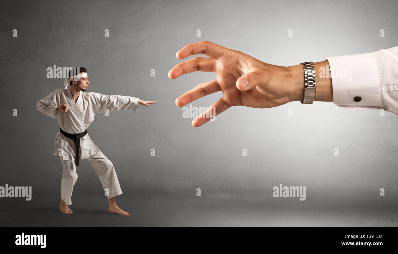 Small karate man fighting with big hand Stock Photo - Alamy
