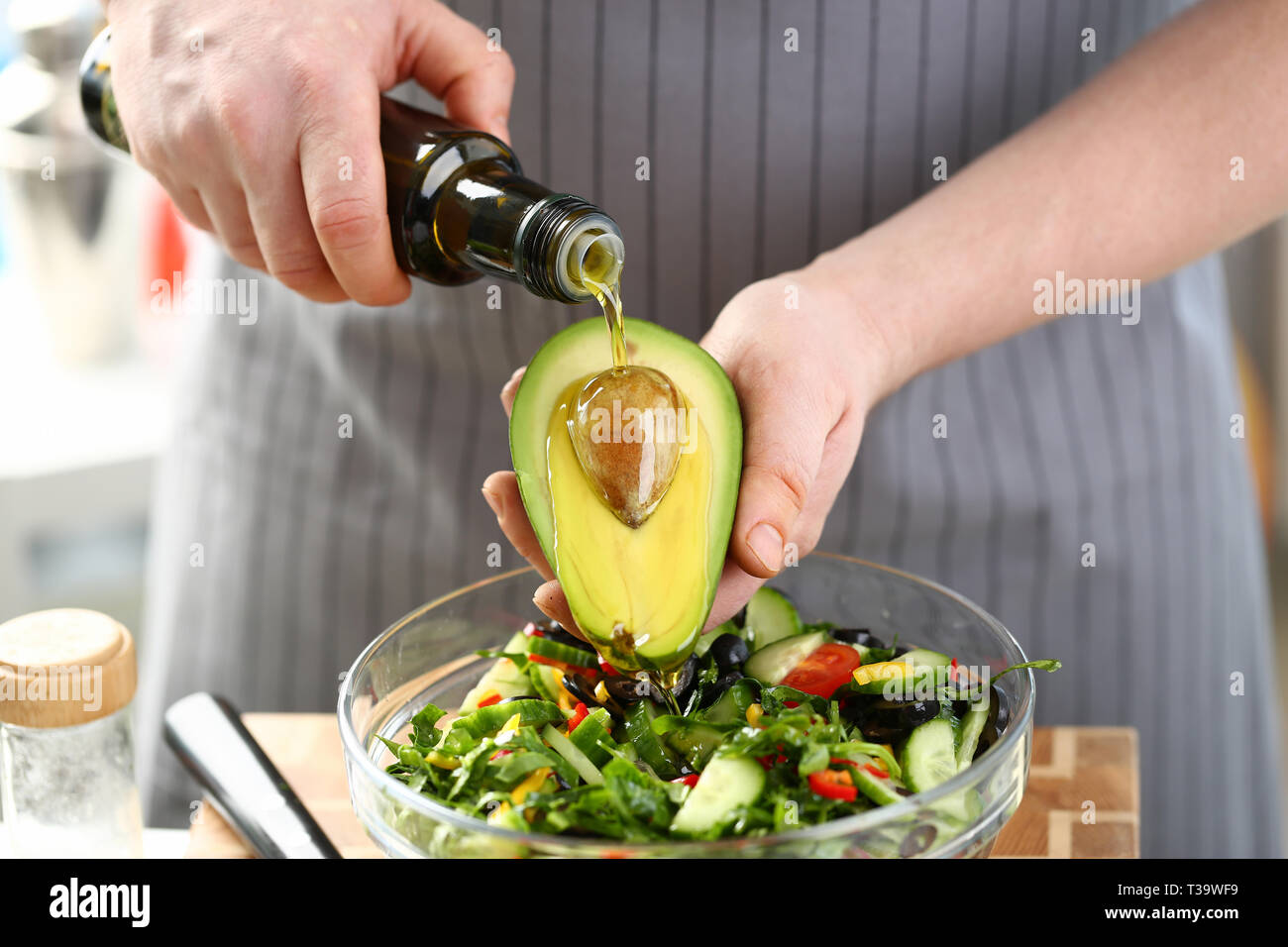 Male cook at home holds bottle of olive Stock Photo - Alamy