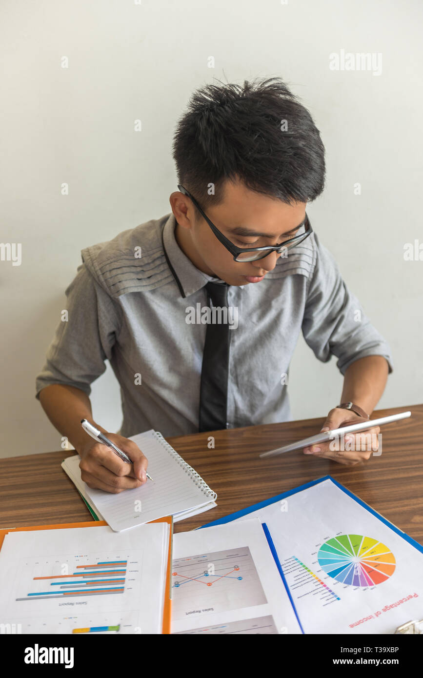 Vertical photo of young office man using tablet Stock Photo - Alamy