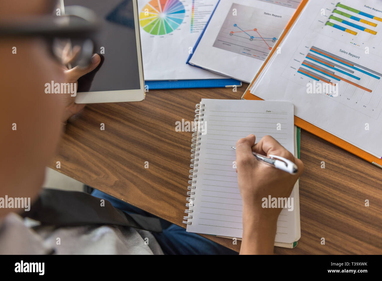 Young man writing notes in the office Stock Photo - Alamy