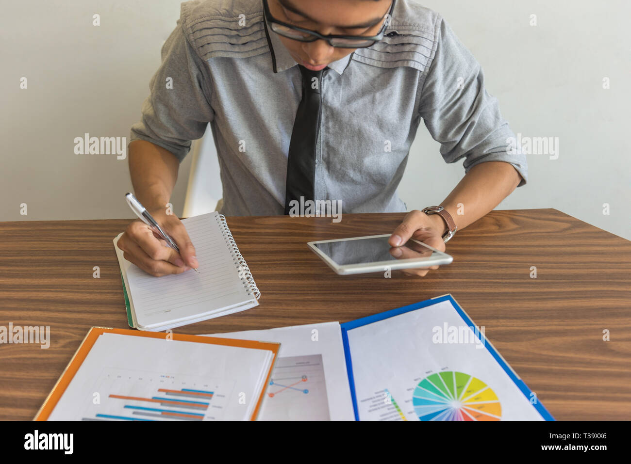 Office man holding tablet and writing note Stock Photo - Alamy