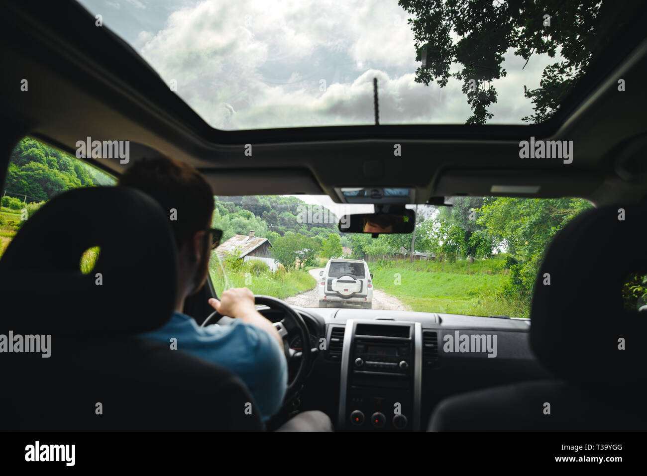 man driving suv car by forest trail road. adventure time Stock Photo ...