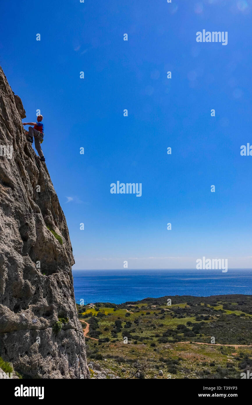 Rock climber on cliffs with blue sea at Zobolo, southern Peleponnese ...