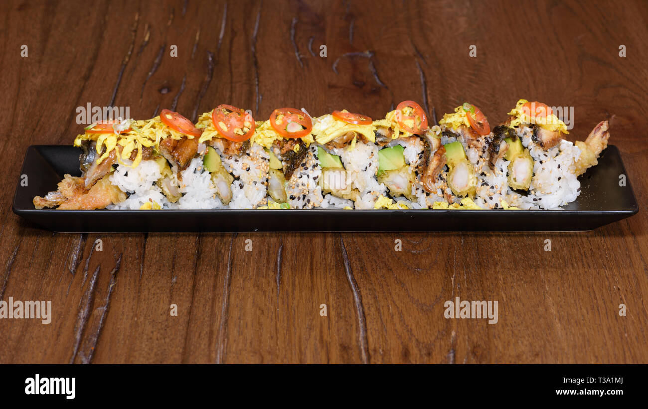 special sushi roll with roasted eel, shrimp in tempura, cherry tomatoes ...