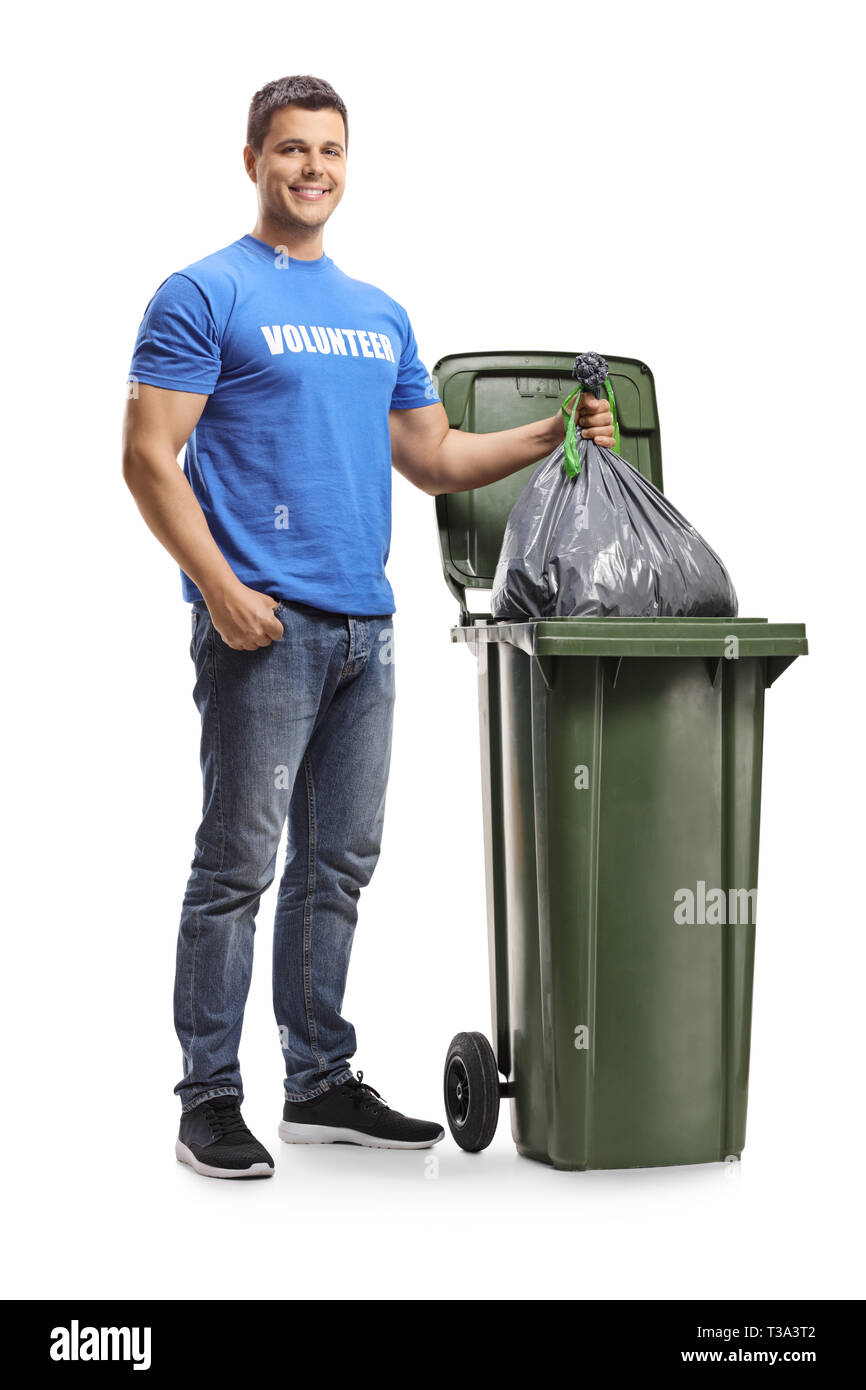 Full length portrait of a young male volunteer throwing a plastic bag ...