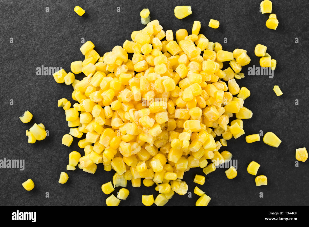 Frozen sweet corn kernels photographed overhead on slate (Selective ...