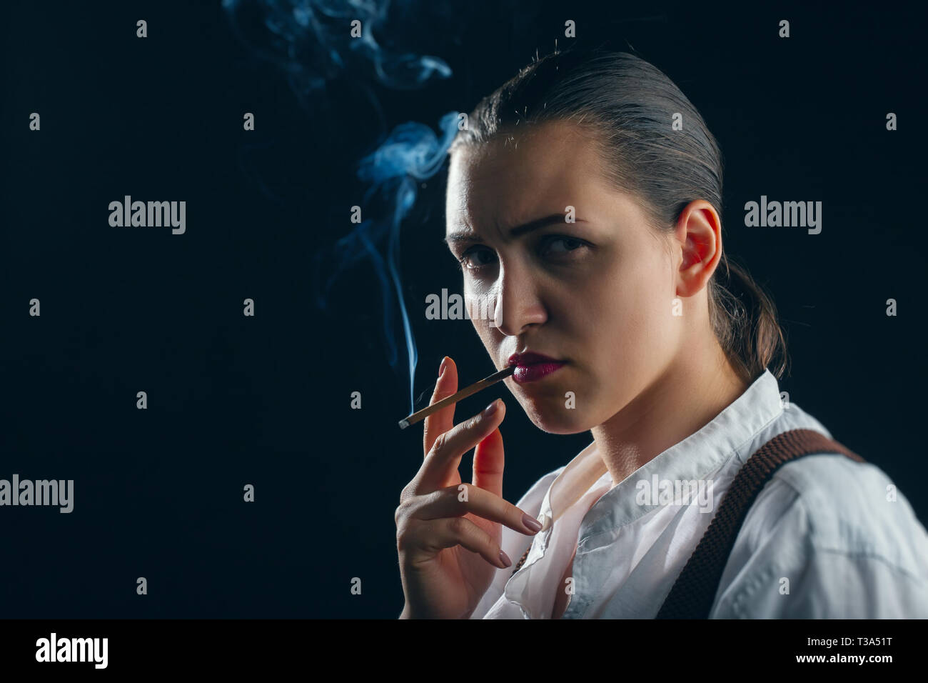 serious woman smoking cigarette on black background Stock Photo - Alamy