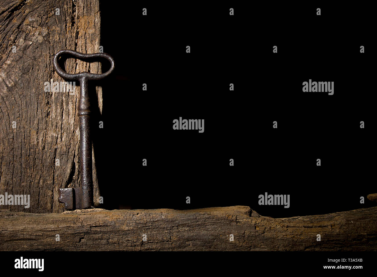 Vintage key hanging on an old log Stock Photo - Alamy