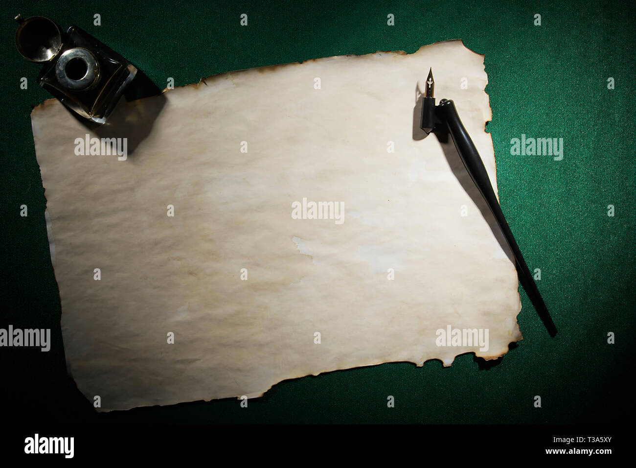 Paper, quill and inkwell on a table with green cloth Stock Photo - Alamy