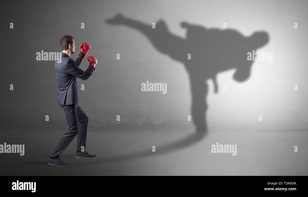Businessman fighting with his strong karate man shadow Stock Photo - Alamy