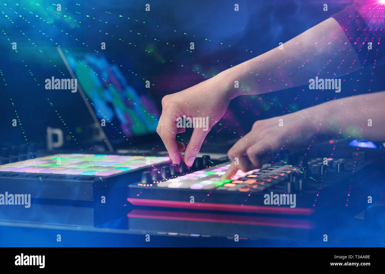 Hand mixing music on midi controller with party club colors around ...