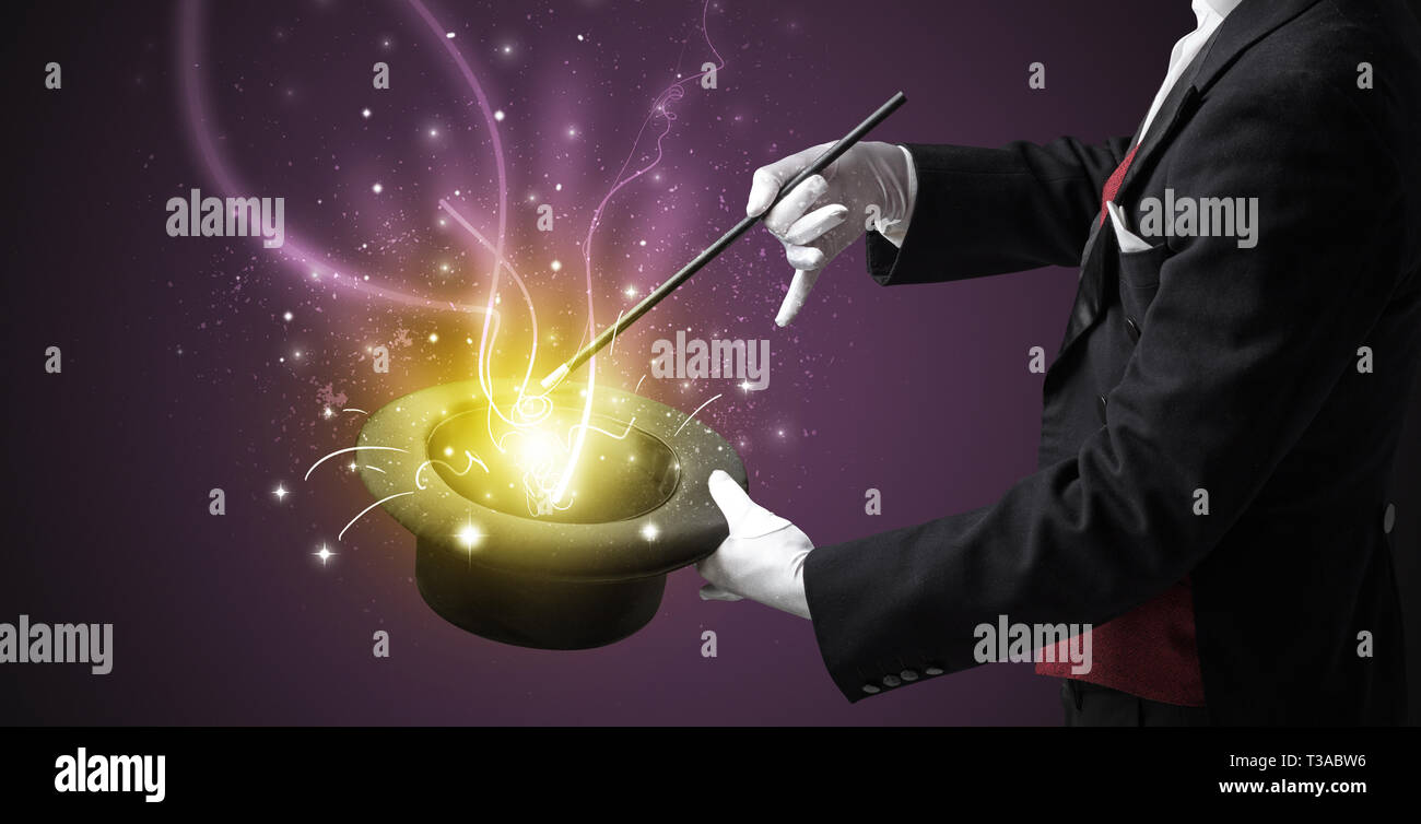 Magician hand conjure with wand light from a black cylinder Stock Photo ...