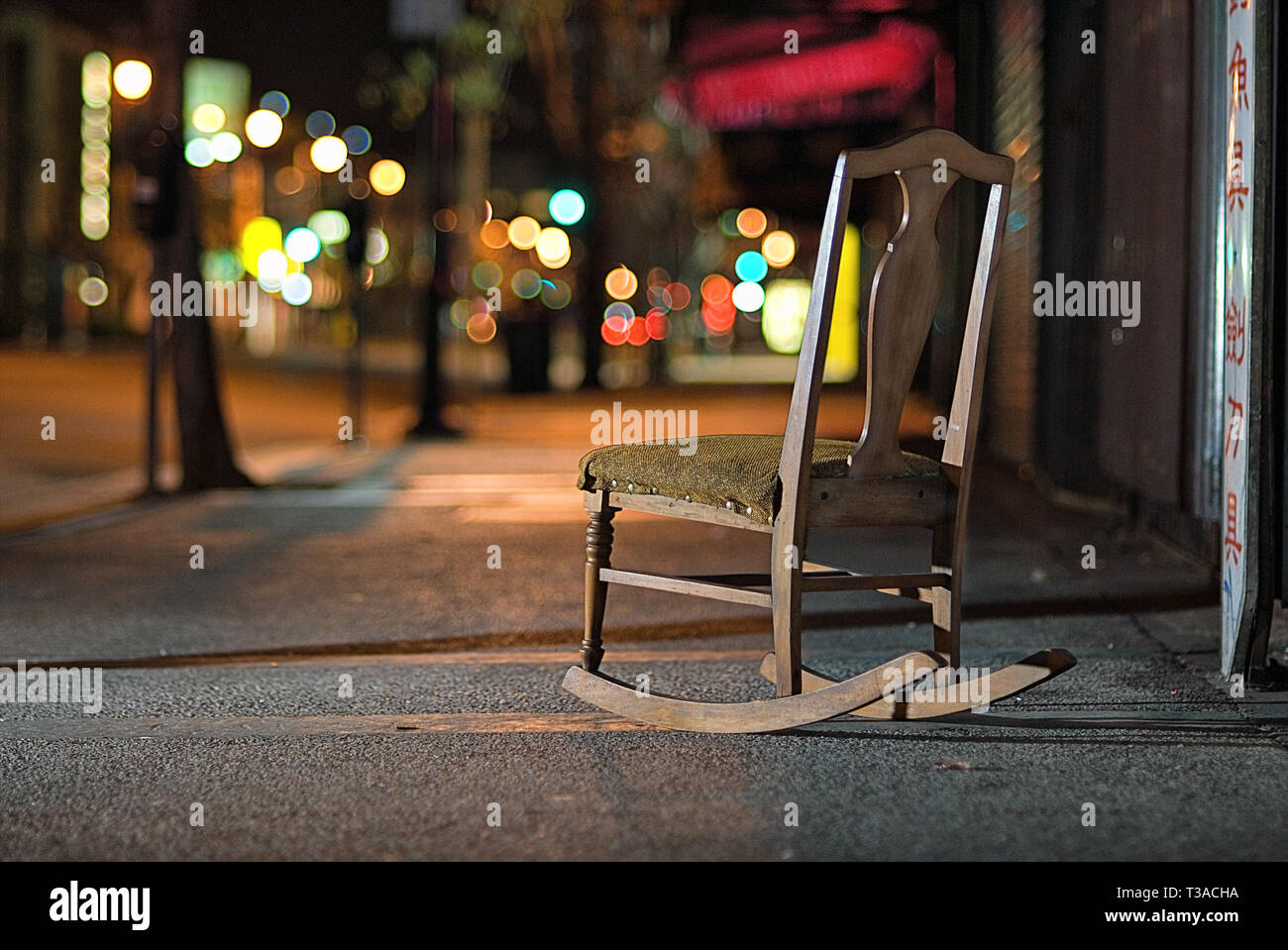 Rocking chair on the sidewalk of a city street Stock Photo - Alamy