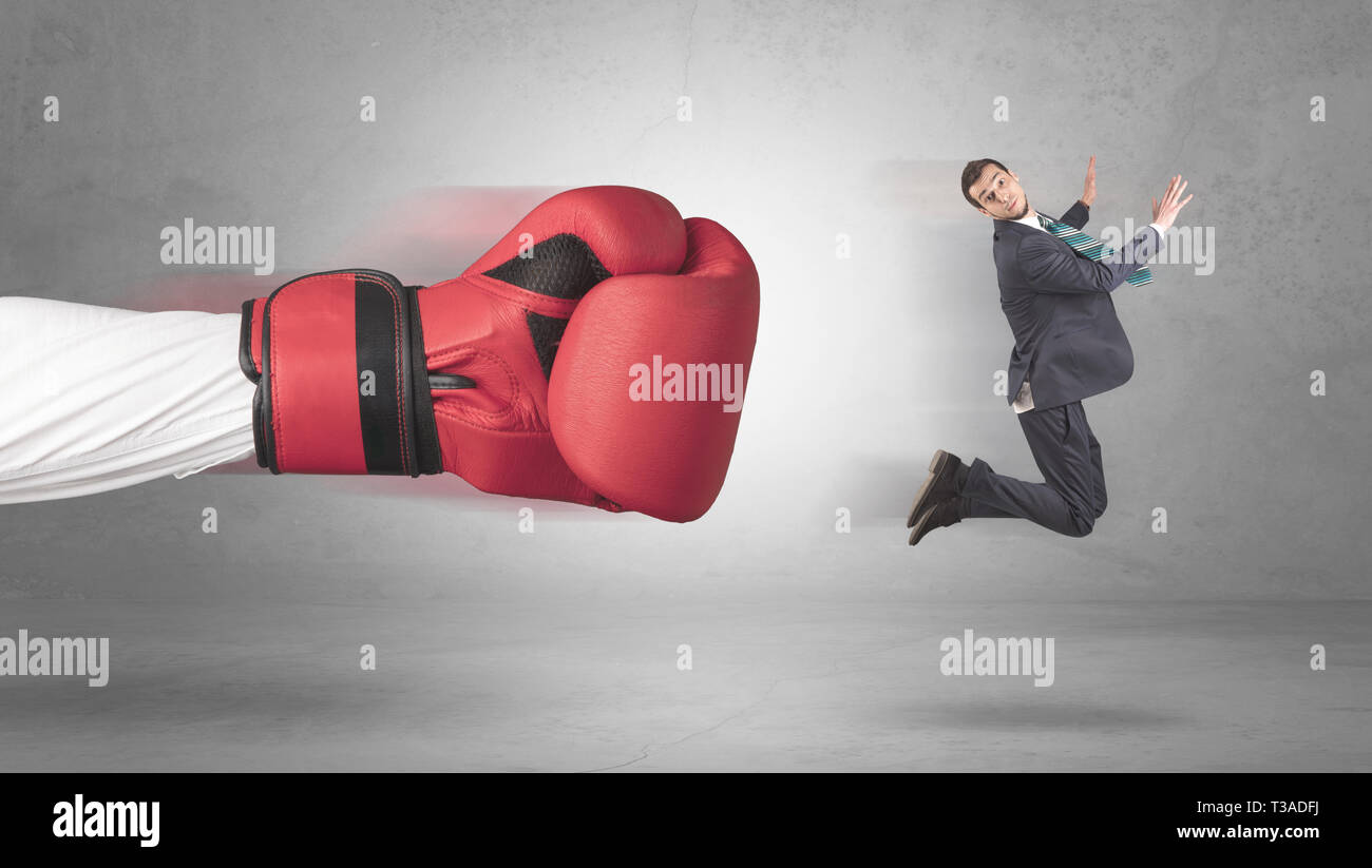 Businessman gets a hit from a giant hand with boxing gloves Stock Photo ...