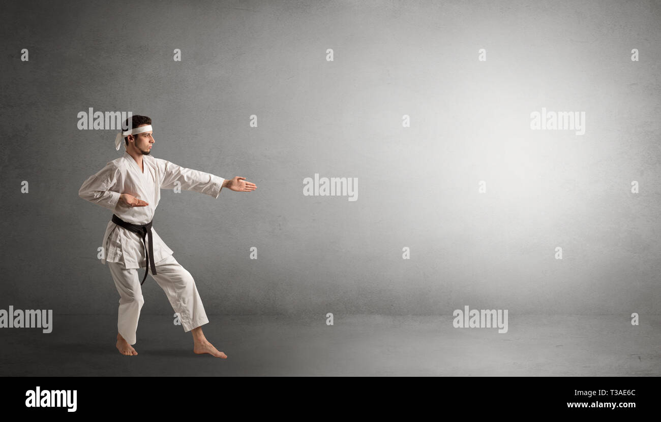 Small karate man fighting in an empty grey copy space Stock Photo - Alamy