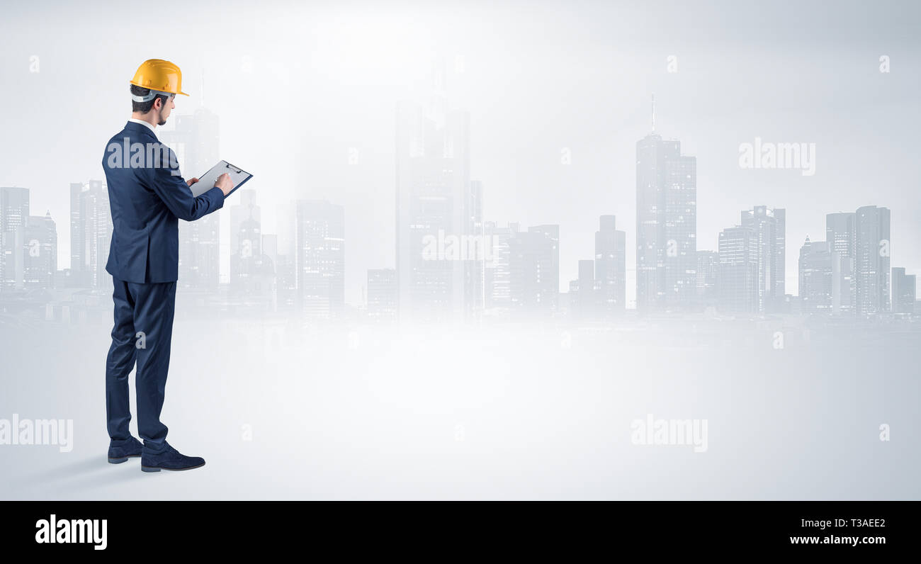 Young supervisor architect standing and looking at a big city panorama ...