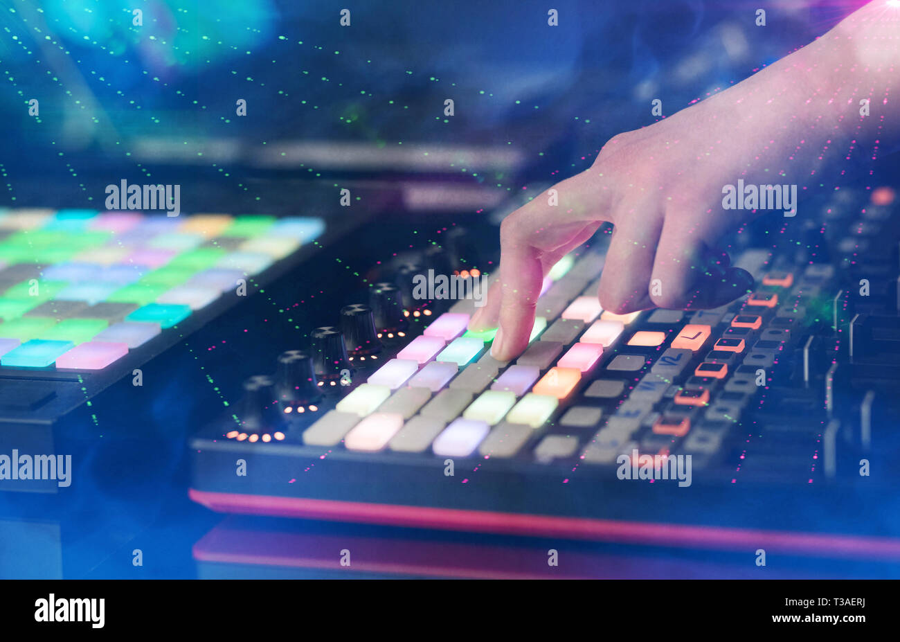 Hand mixing music on midi controller with party club colors around ...