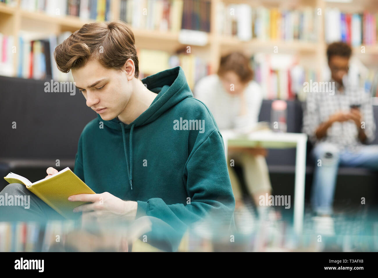 Student guy reading book Stock Photo - Alamy