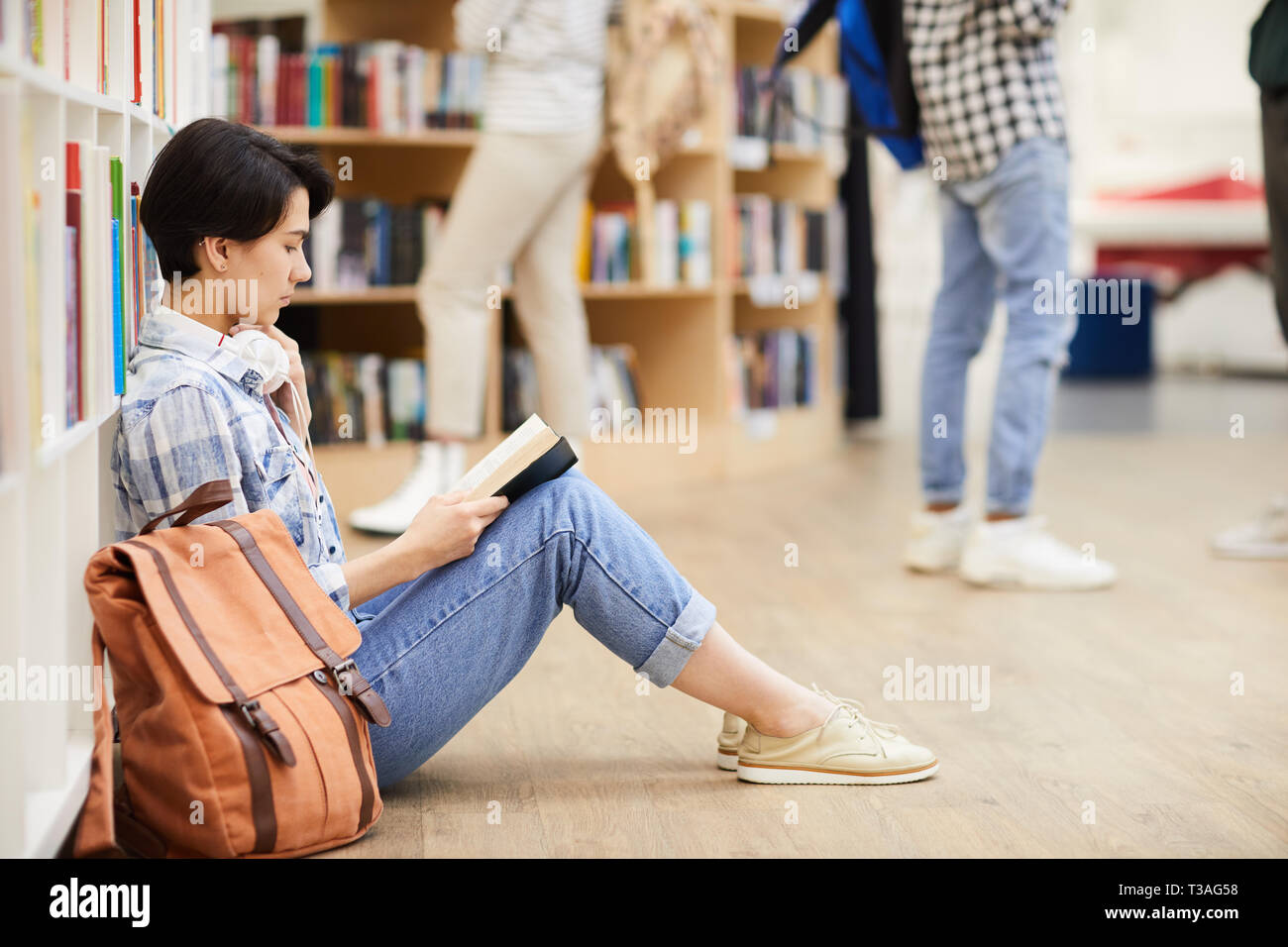 Girl reading book library floor hi-res stock photography and images - Alamy