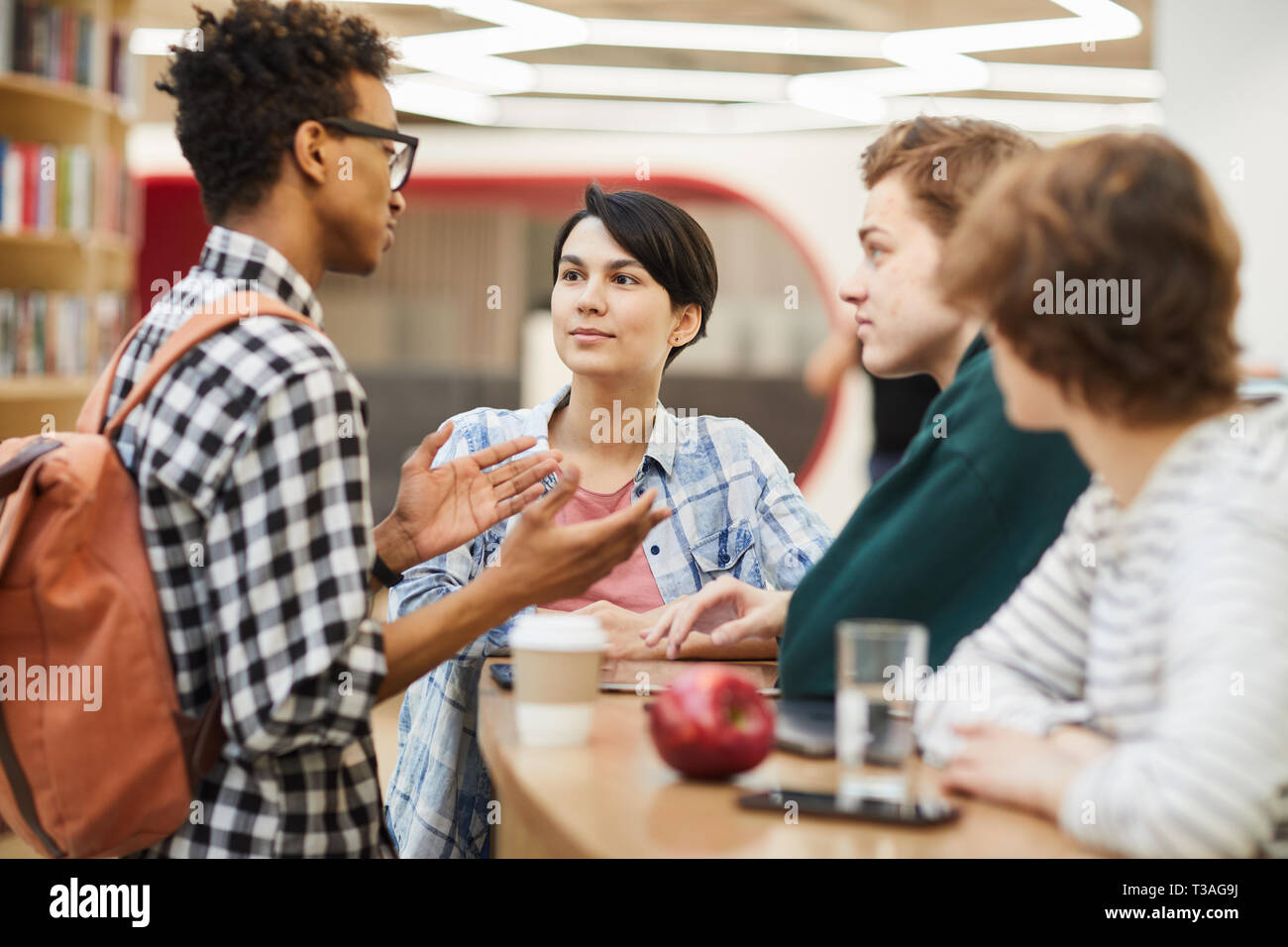 Multiethnic high school friends discussing project Stock Photo - Alamy