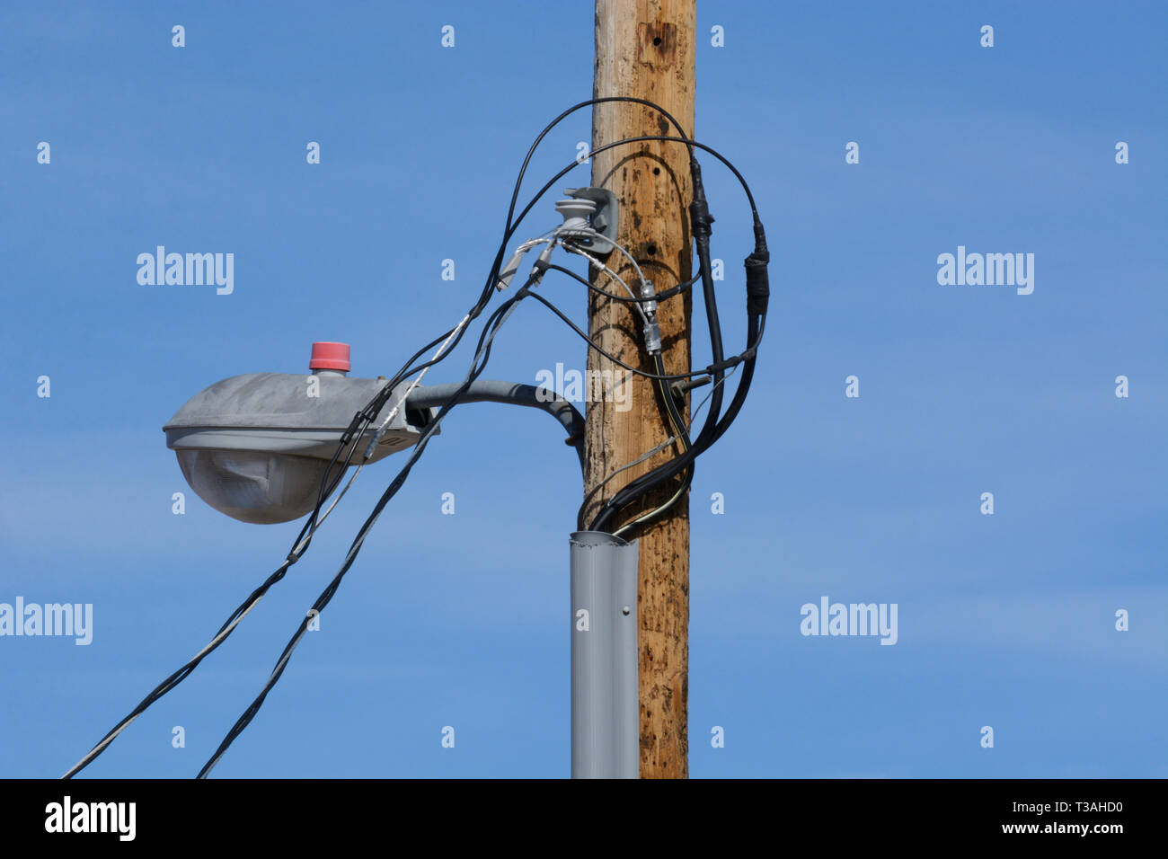 New urban streetlight on new wooden pole with new temporary power line ...