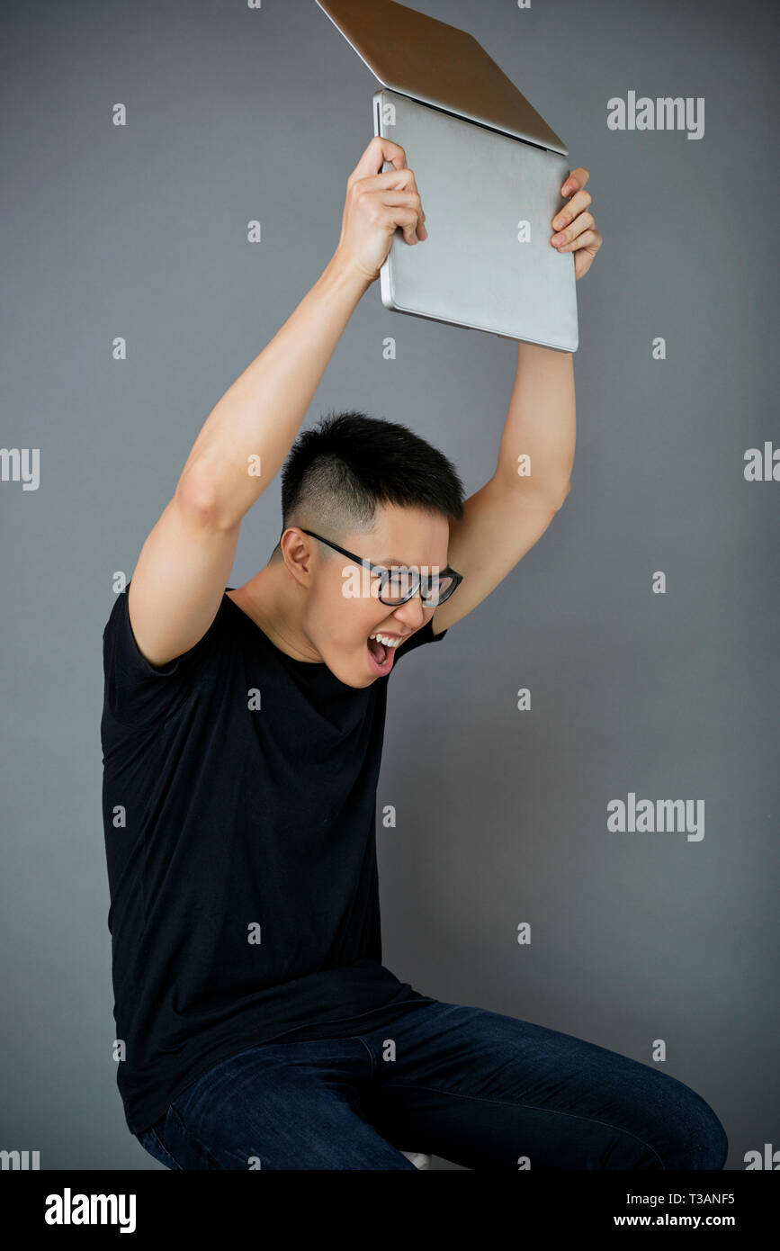 Software developer breaking laptop Stock Photo - Alamy